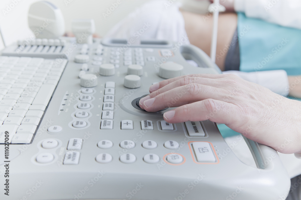 Hand of sonographer using control panel whilst doing ultrasound scan ...