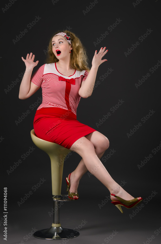 Beautiful young pin-up woman with wow face sitting on the bar chair ...