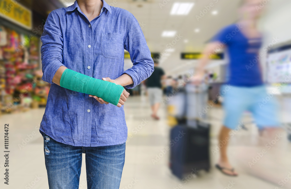 Injured woman with green cast on hand and arm on traveler in mot Stock ...