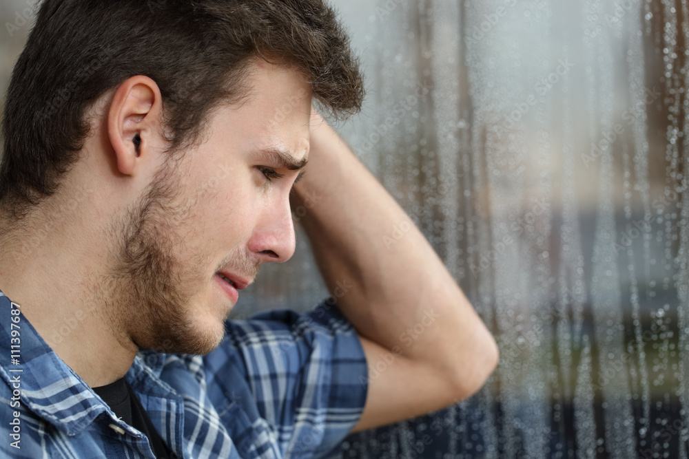 Sad man looking through window a rainy day Stock Photo | Adobe Stock