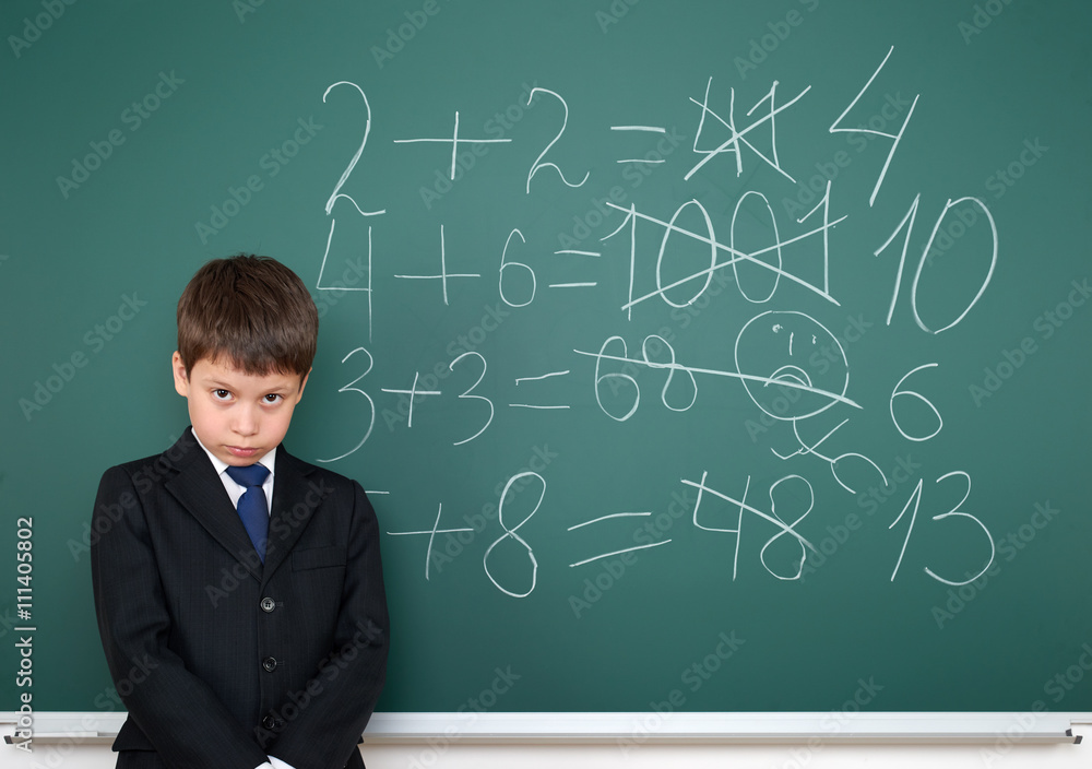 school boy decides examples math wrong on chalkboard background ...
