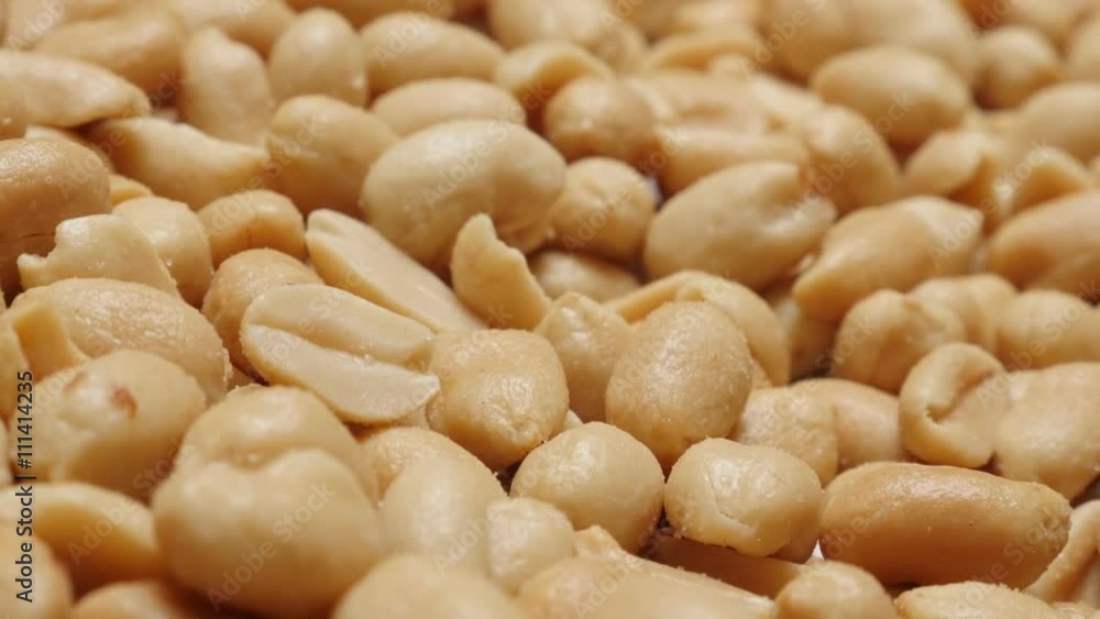 Roasted Arachis hypogaea groundnut pile slow tilting food background 4K ...