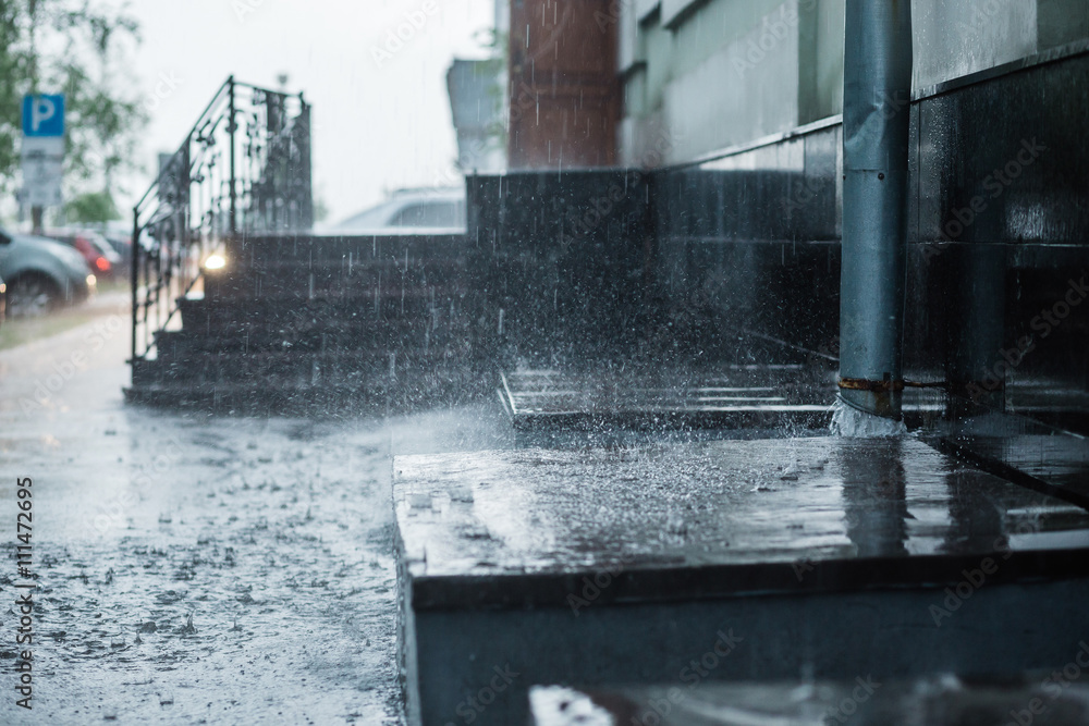 Rain water flowing from a metal downspout during a heavy rain. concept ...