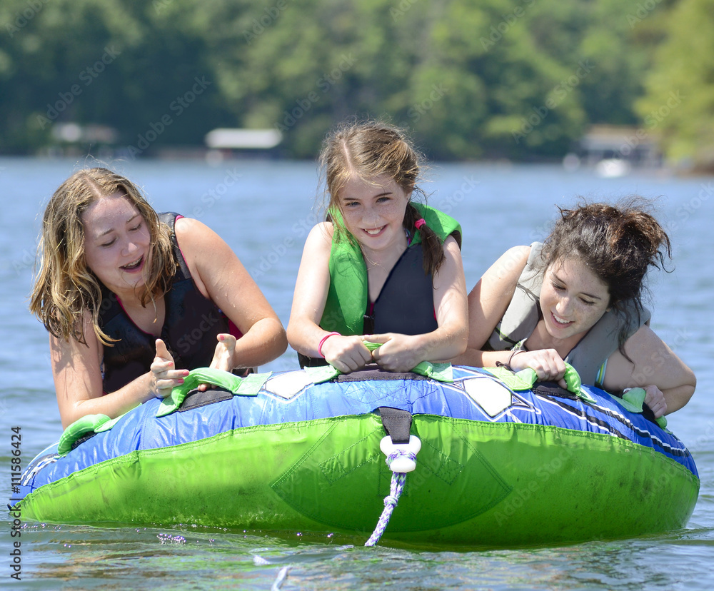 Young teenage girl doing a trick on a float behind a boat. Stock Photo ...