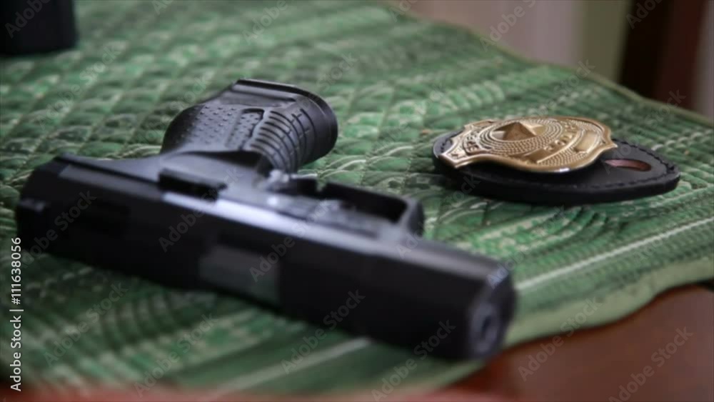 The camera brings in and out of focus a nine millimeter pistol and a ...