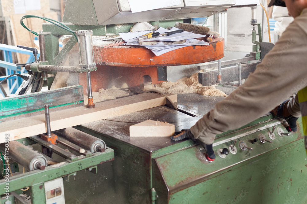 Building a wall for frame house. Worker cutting wooden balk on an ...