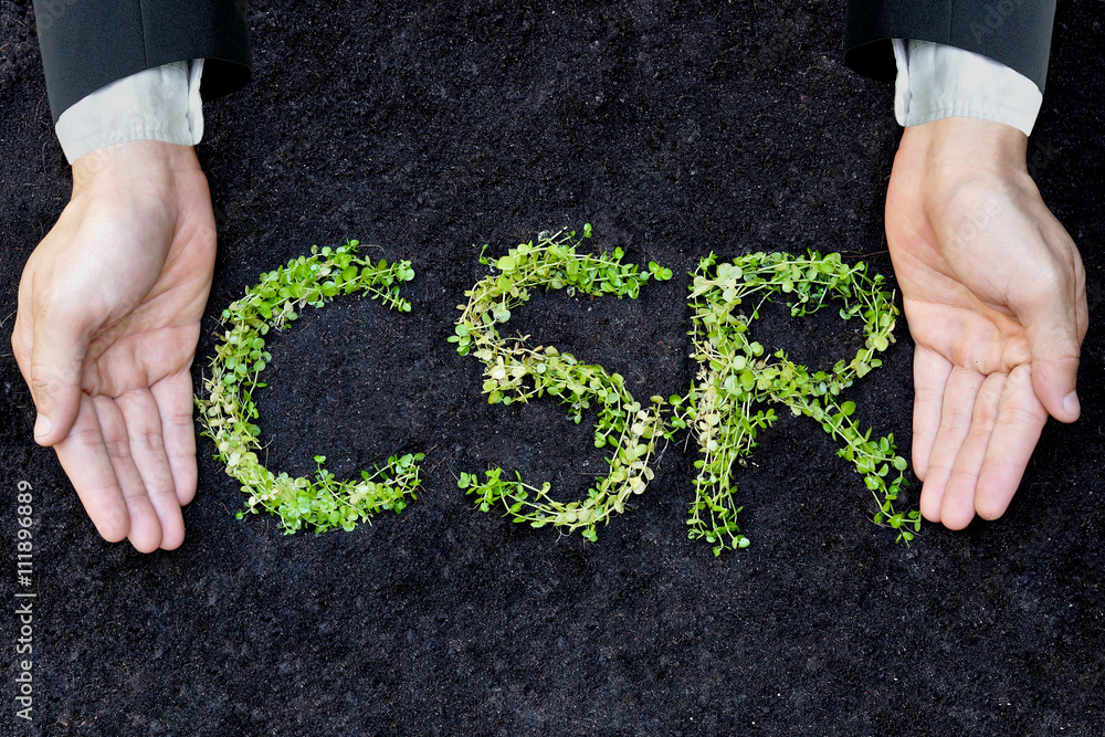 CSR. Small green plants arranged in csr shape with supporting hands on ...