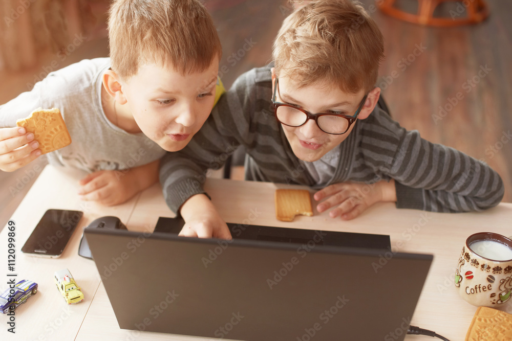 Happy boy sitting With laptop computer Stock Photo | Adobe Stock