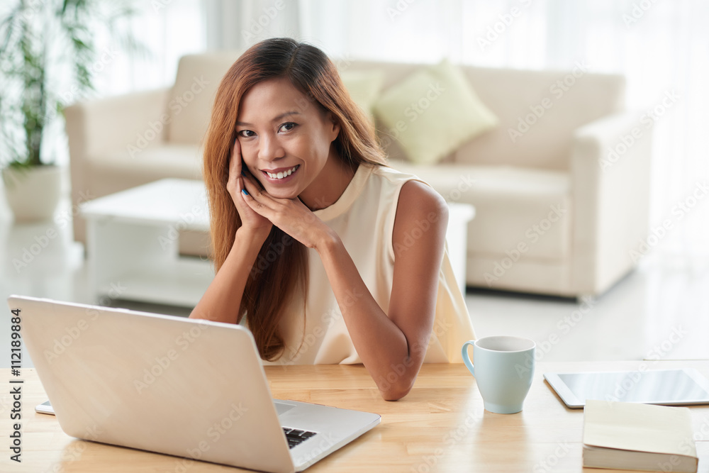 Pretty Filipino young woman working on laptop at home Stock Photo ...