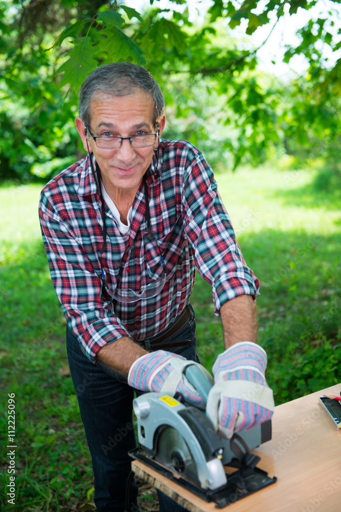 Carpenter cutting a panel with a circular saw Stock Photo | Adobe Stock