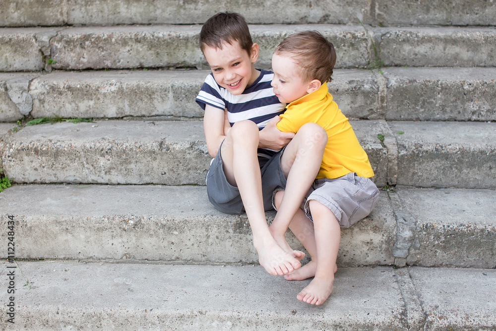 cheerful brothers playfully fighting and tickle each other. Two ...