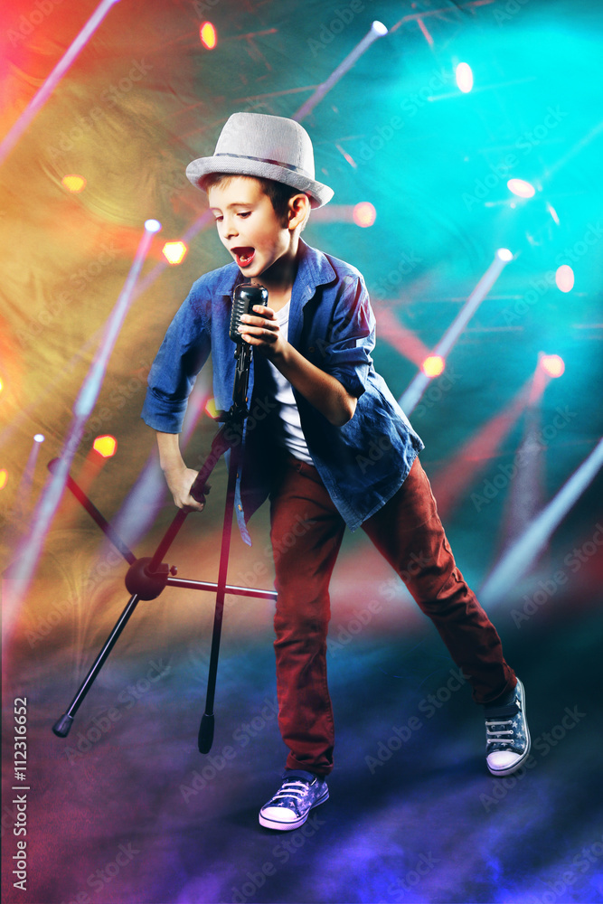 Little boy singing with microphone on laser rays background Stock Photo ...