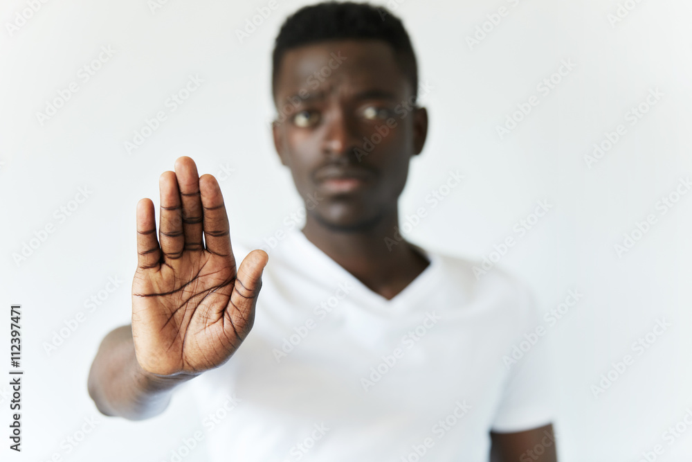 Headshot of young black African man wearing white T-shirt, looking at ...