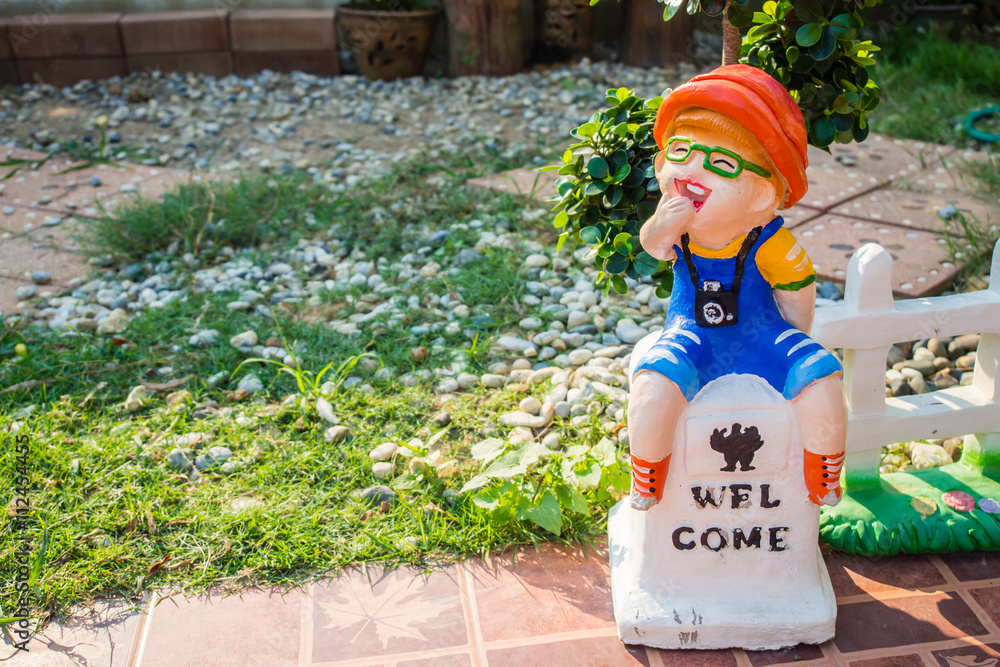 Smiley doll sitting on white rock in gargen Stock Photo | Adobe Stock