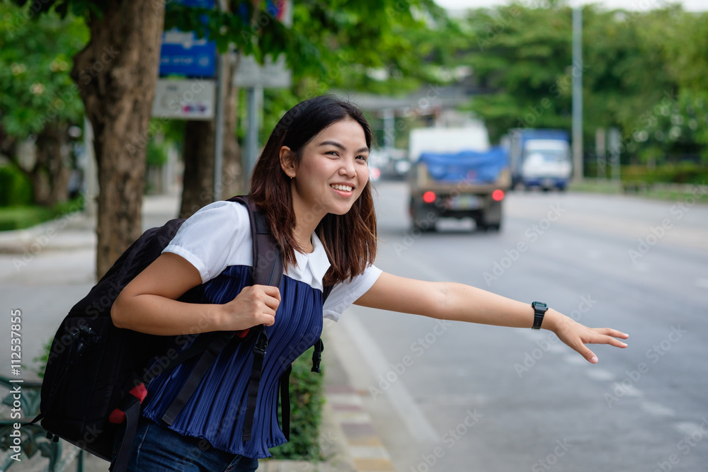 Young woman standing at bus stop on street city. Asian woman waiting ...