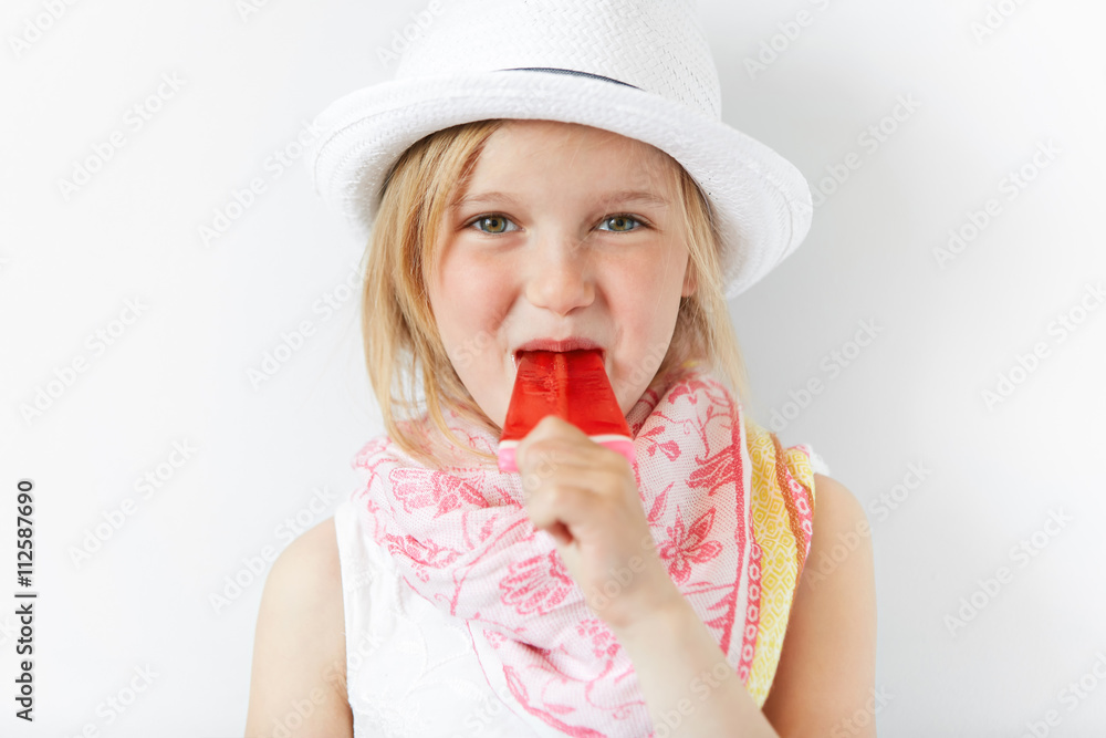 Little blond girl eating popsicle and smiling with her eyes in ...