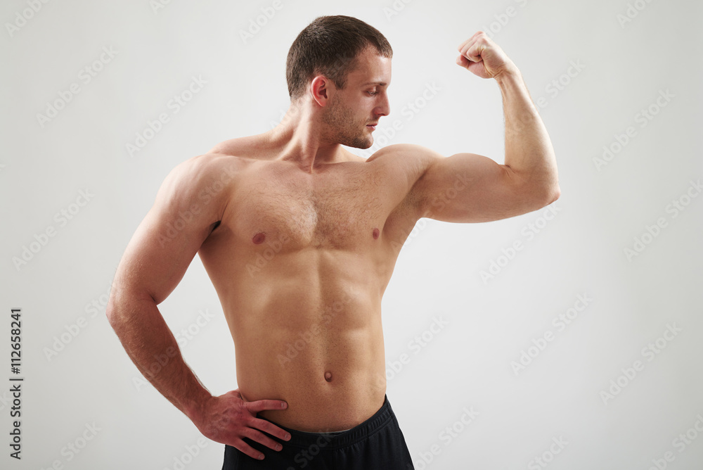 Sexy bare-chested man showing biceps on left arm Stock Photo | Adobe Stock