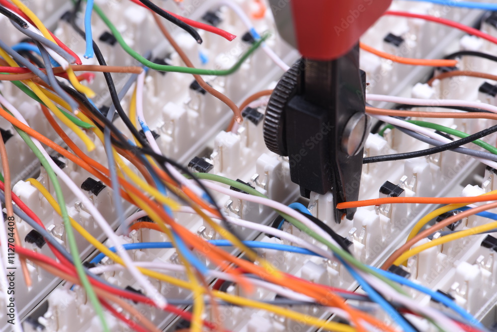 Telecommunication main distribution frame with cables and punching tool ...