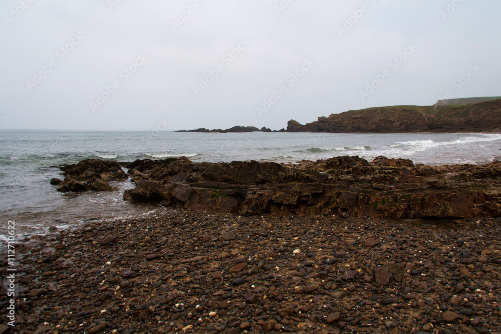 Waves over the rocks on the beach Stock Photo | Adobe Stock