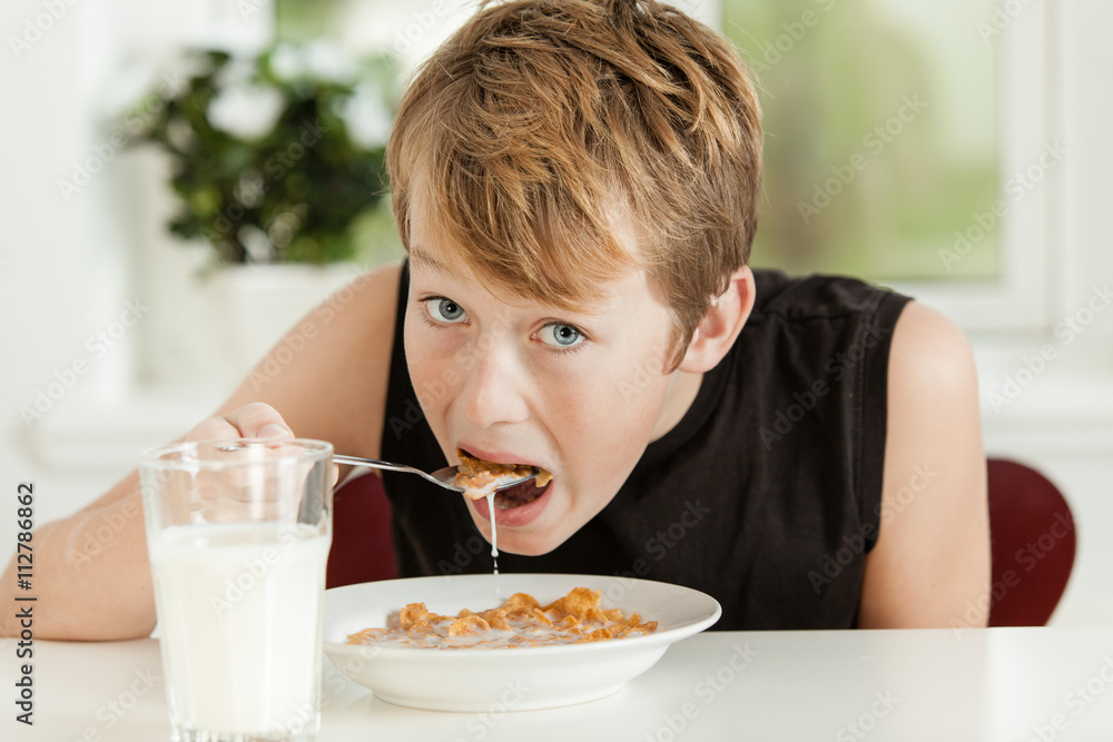 Teenage Boy Eating Breakfast Cereal in Morning Stock Photo | Adobe Stock