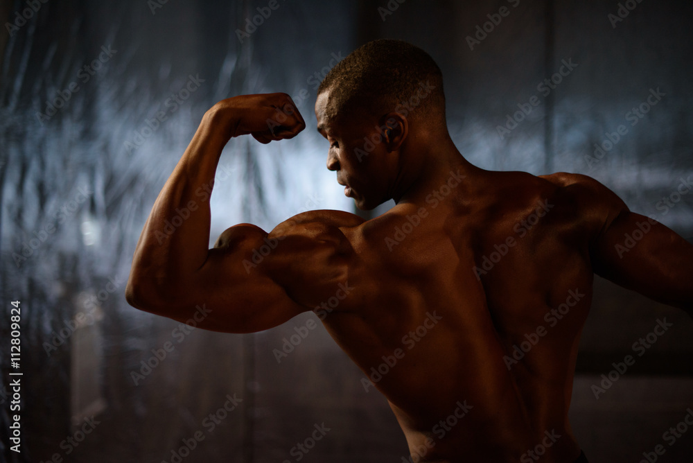 Side view of black african american fitness model showing muscles in ...