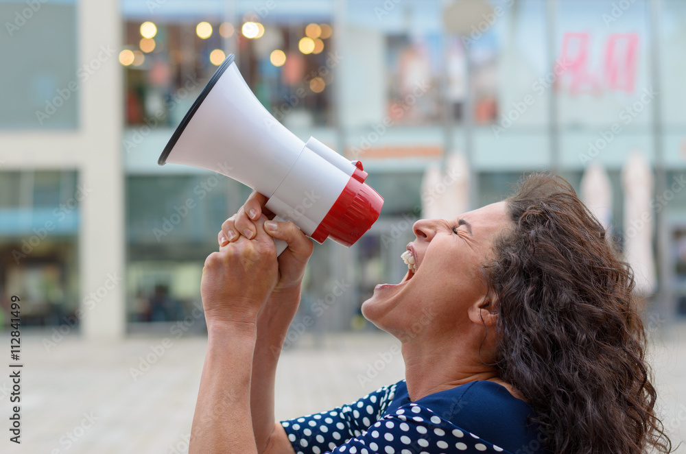 Young woman protester shouting into a megaphone Stock Photo | Adobe Stock