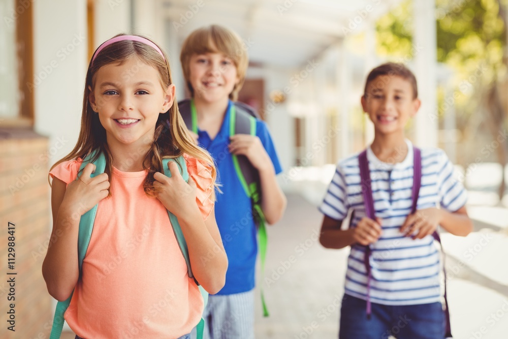 Smiling school kids standing in school corridor Stock Photo | Adobe Stock