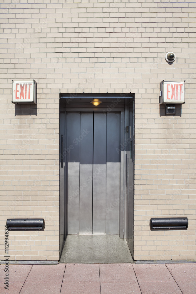An elevator between two EXIT signs Stock Photo | Adobe Stock