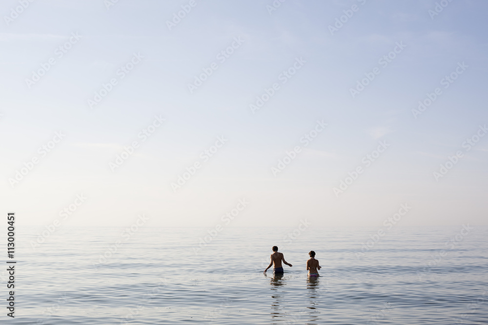 Two people standing in the sea Stock Photo | Adobe Stock