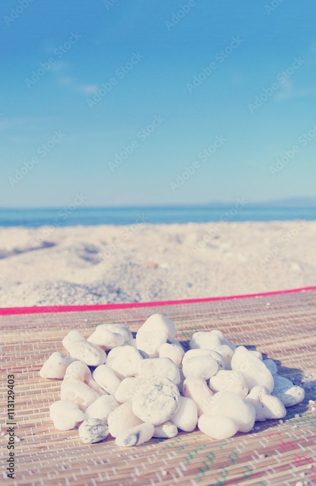 Heap of white pebbles on the white sandy beach, on a sunny day, with ...