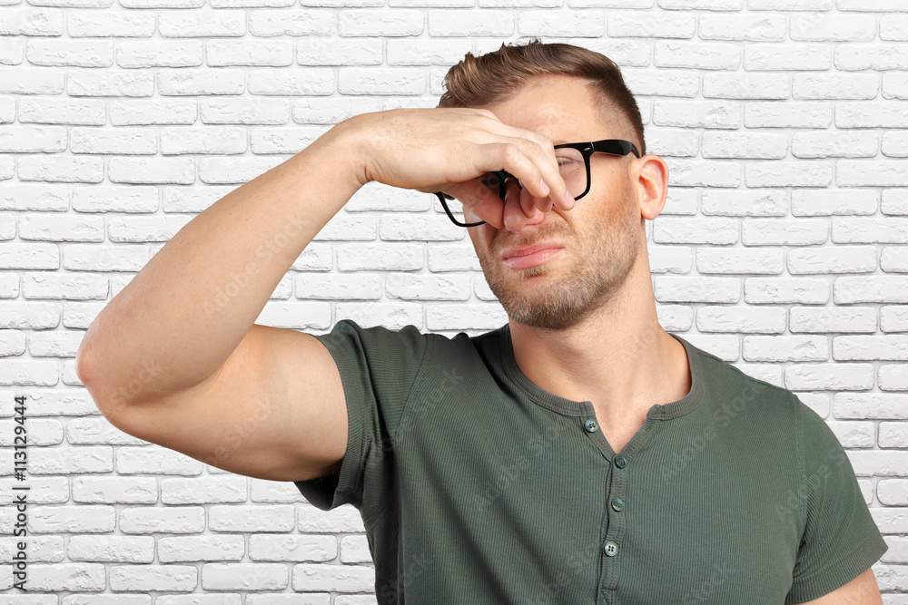 portrait of disgusted man pinches nose with fingers hands looks with ...