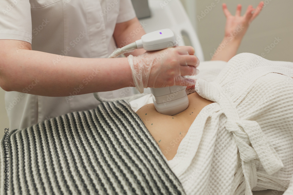 Spa Beautician giving suction pump massage for young female stomach ...