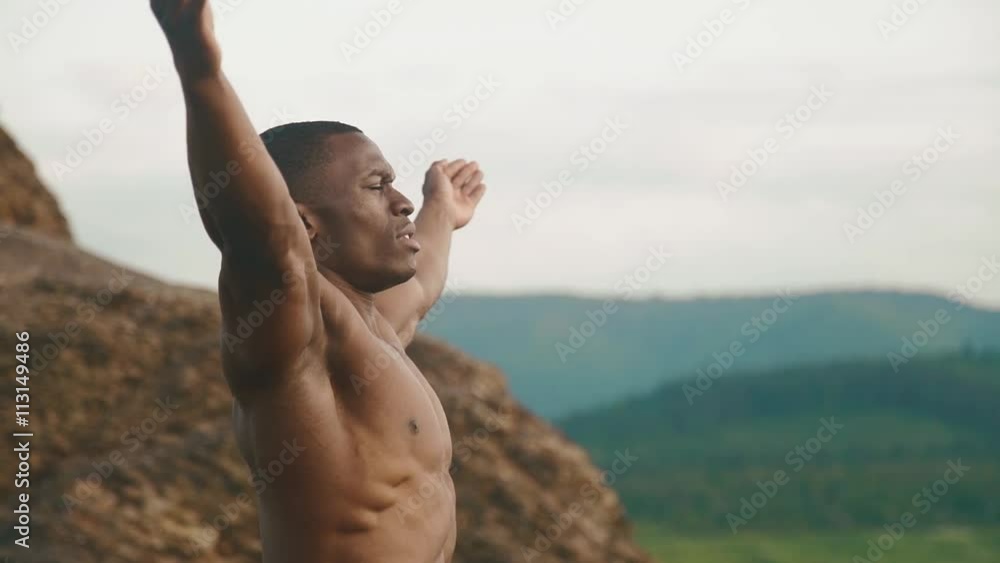 Side view of strong african american bodybuilder stretching outdoor ...