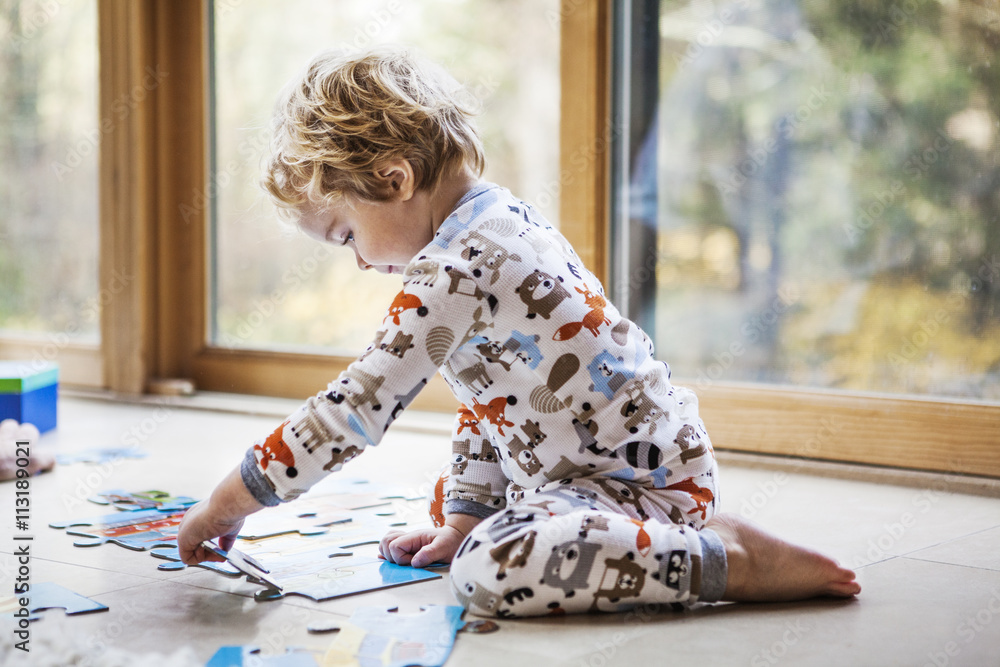 Boy playing jigsaw puzzle at home Stock Photo | Adobe Stock