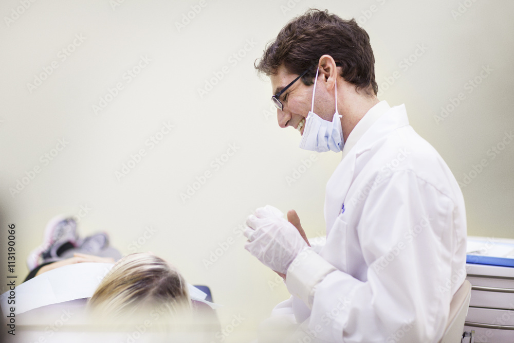 Dentist laughing with patient Stock Photo | Adobe Stock