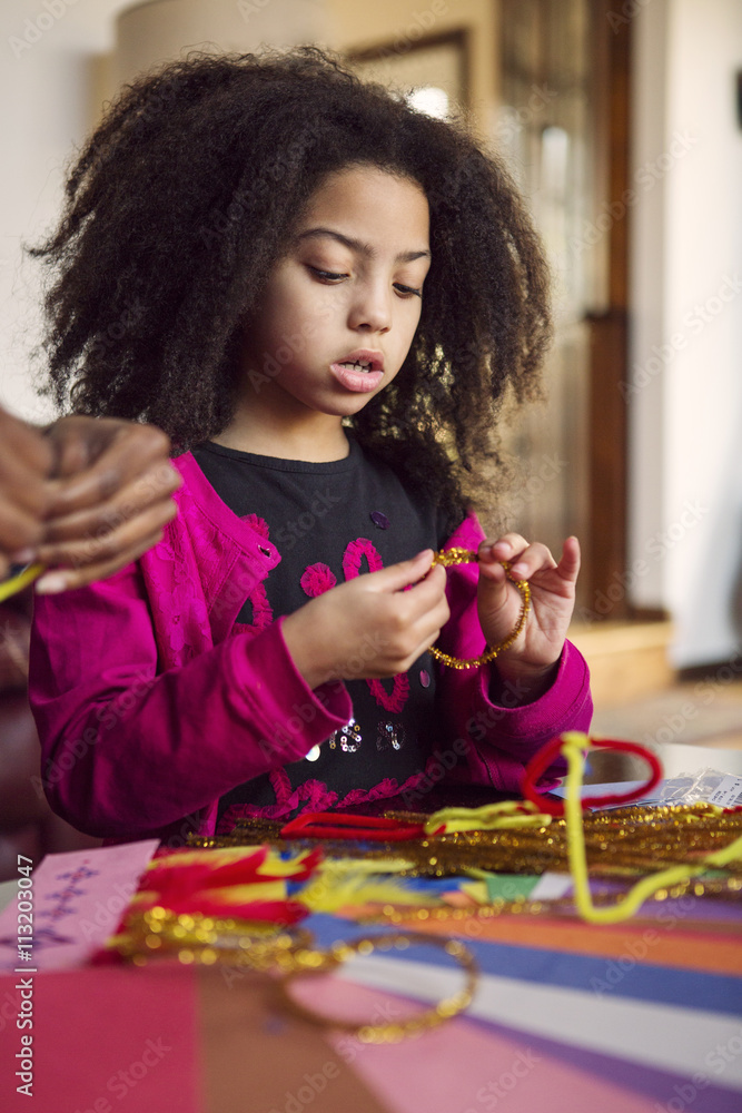 Cute girl making craft with mother at home Stock Photo | Adobe Stock