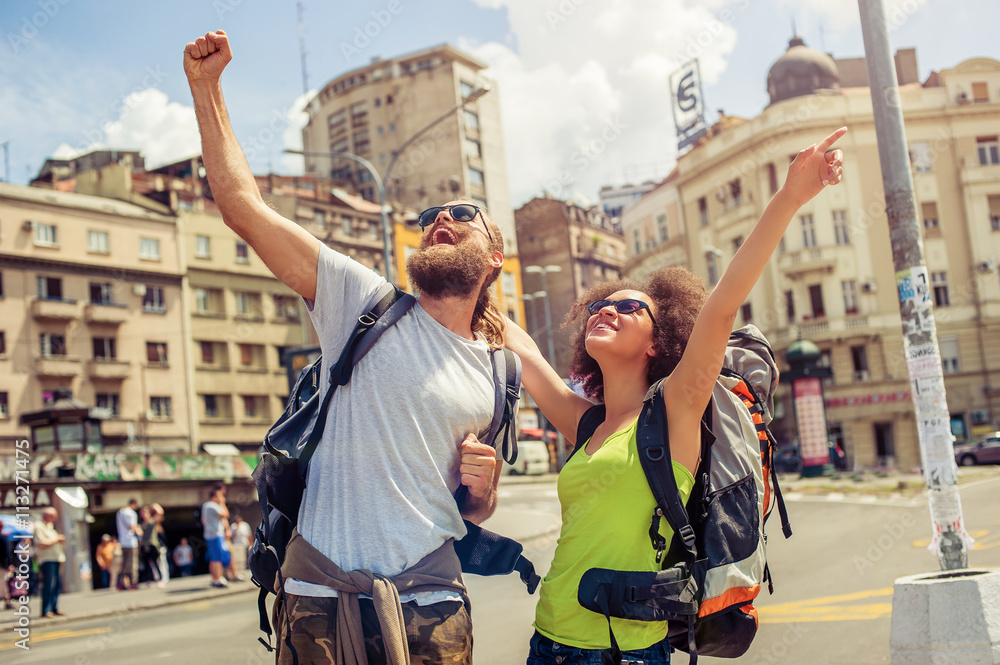Euphoric happy couple of tourists are raising their hands up and ...
