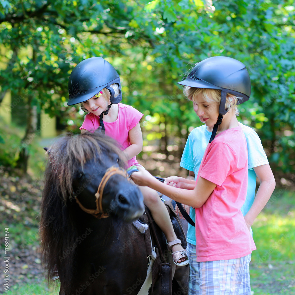 Young children enjoying horse back riding activity. Group of school age ...