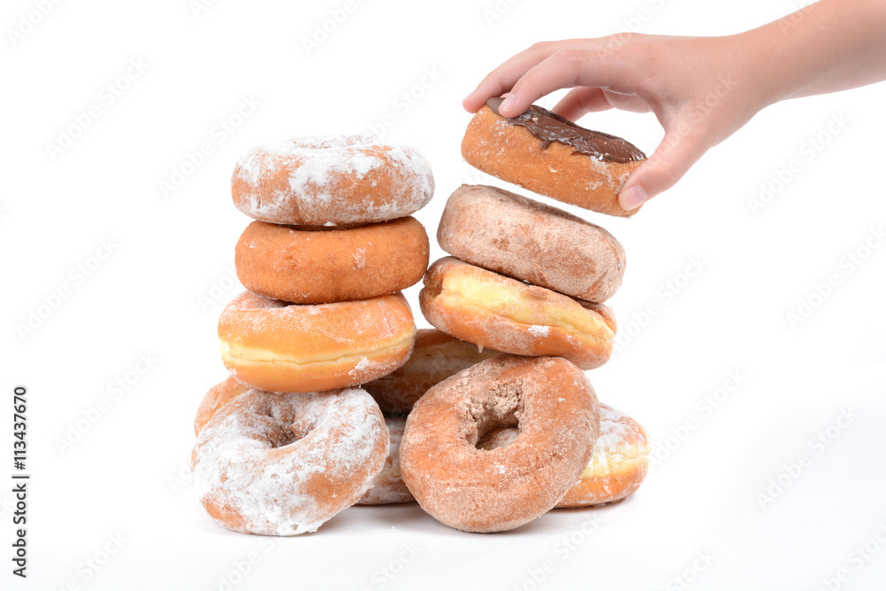 child hand grabbing a donut from a pile isolated on white background ...