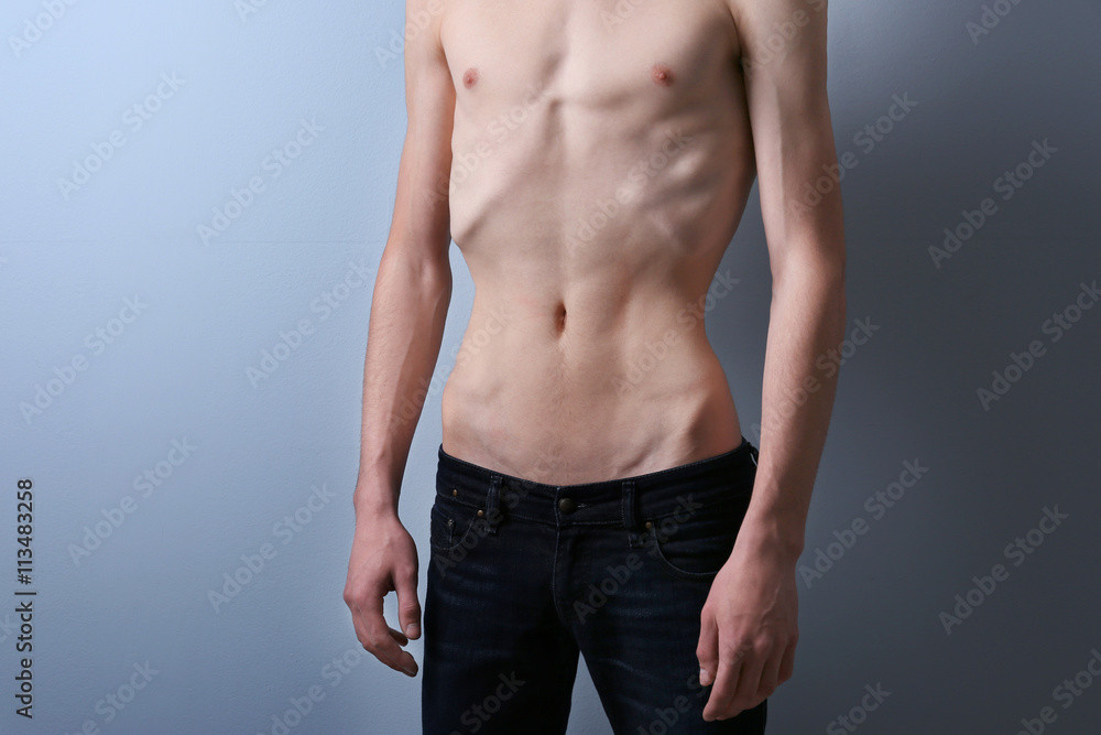 Skinny young man with anorexia on grey background Stock Photo | Adobe Stock