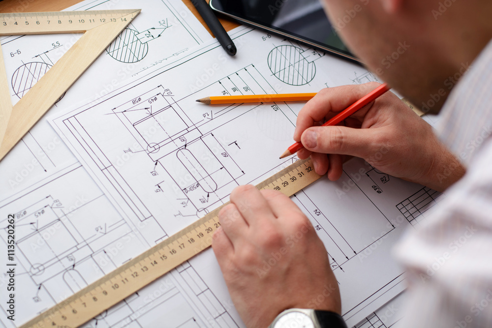 Mechanical engineer at work. Technical drawings. Paper with technical ...