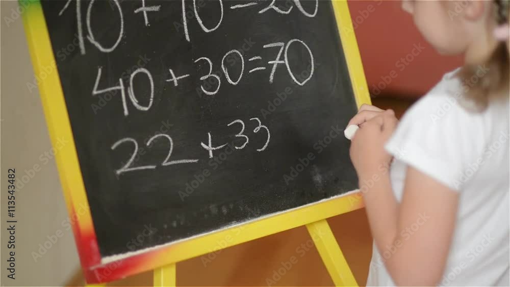 Schoolgirl writes the examples on the board and make a mistake, error ...