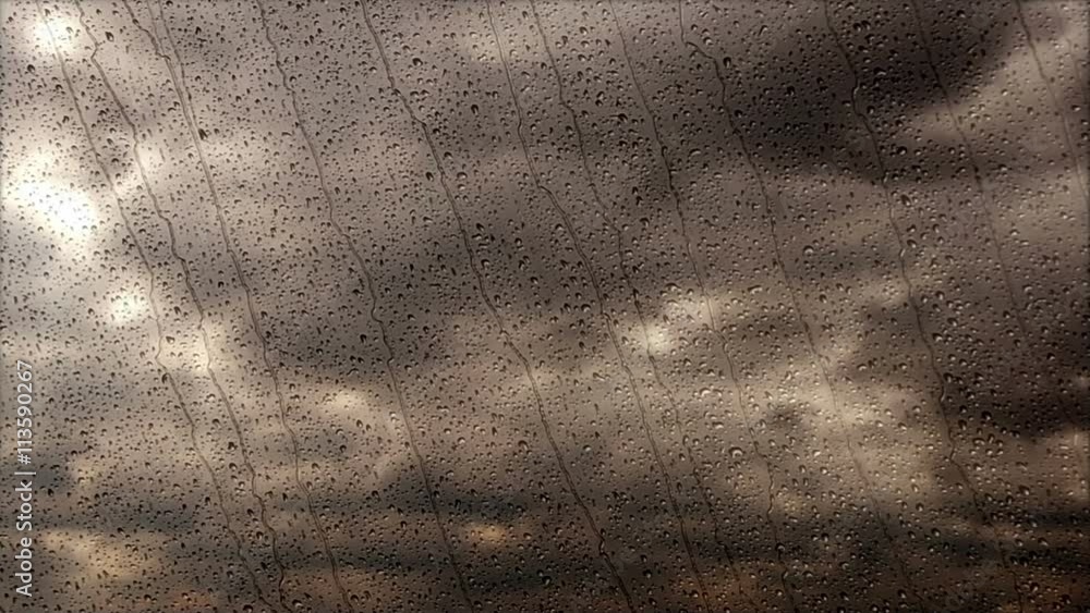Storm clouds flying fast throuth the rainy window, wide angle view ...