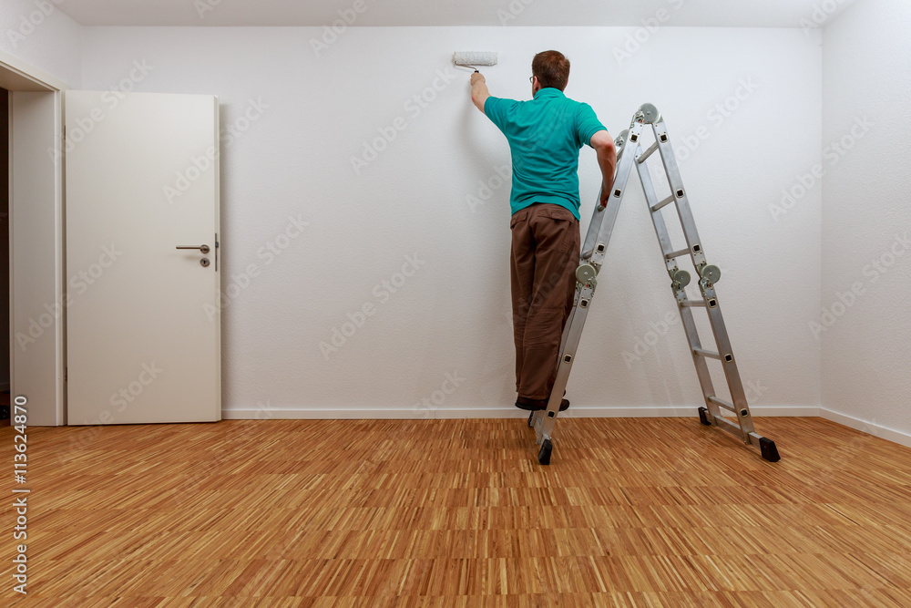 Mann auf Leiter beim Streichen der Wand Stock Photo | Adobe Stock