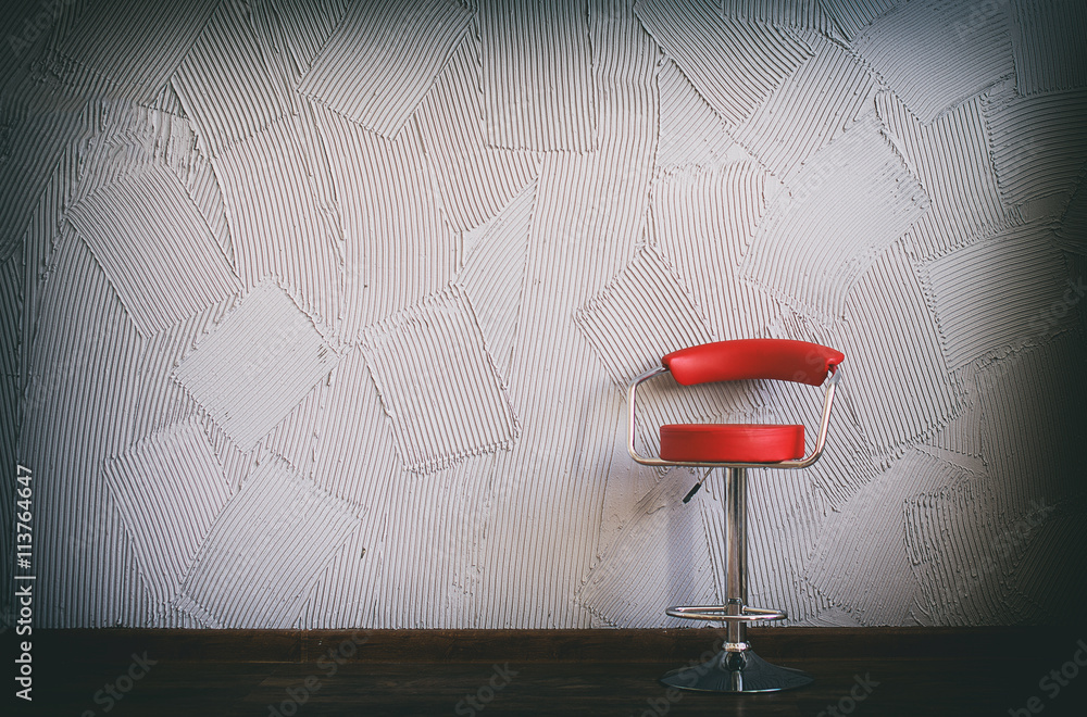 modern red chair in an empty room. in the circle of light there is red ...