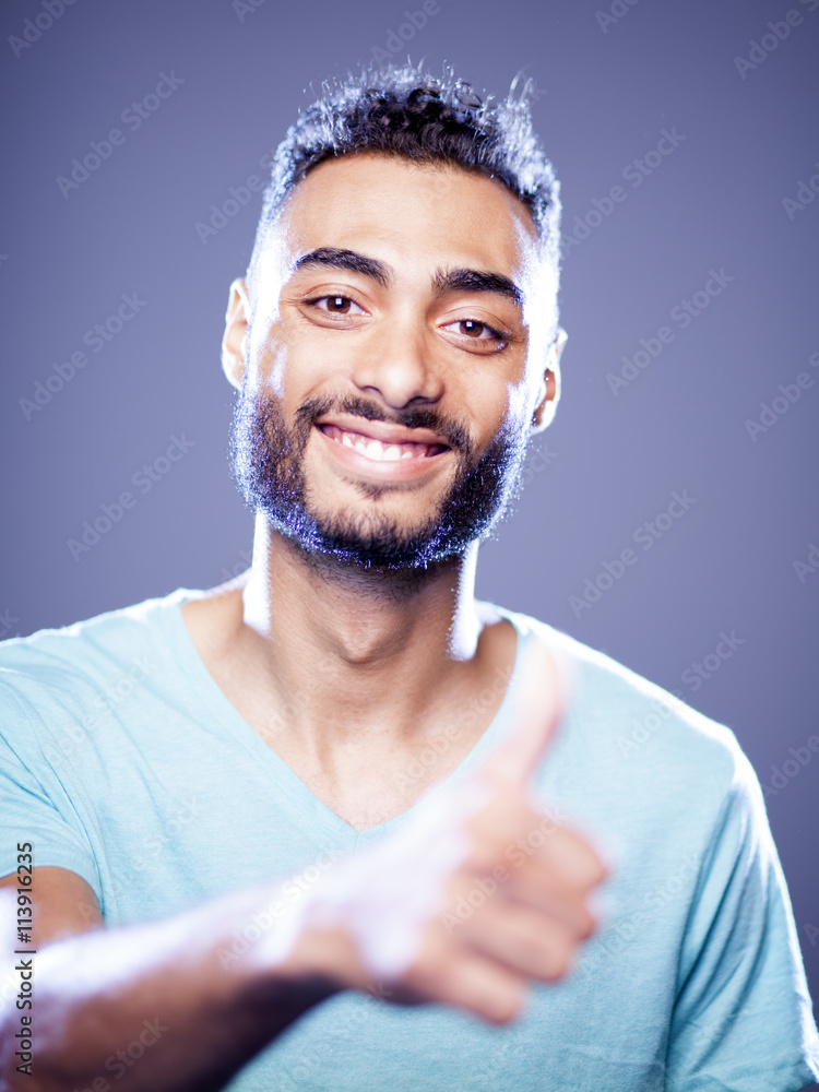 Joven mulato sonriendo y alzando el pulgar Stock Photo | Adobe Stock