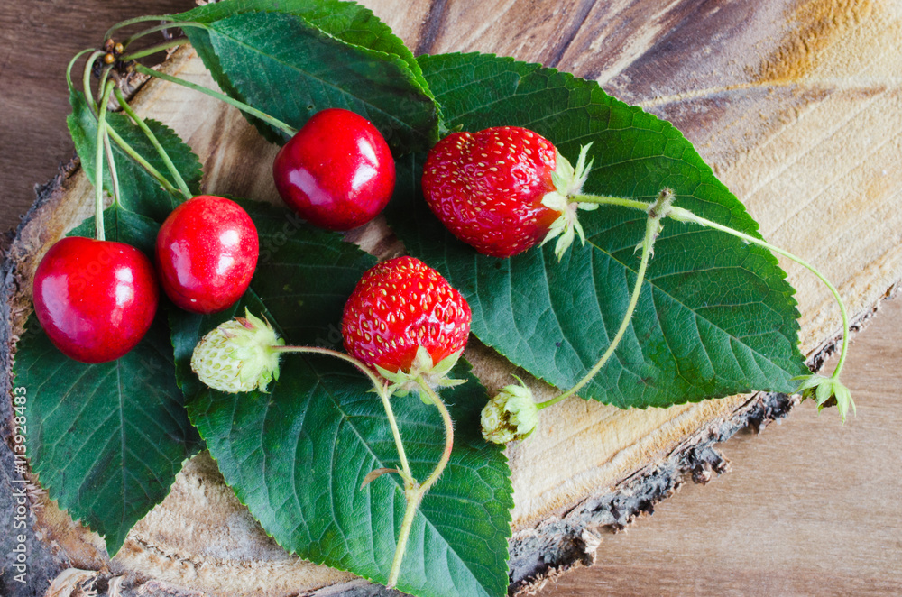 Fresh ripe organic strawberry and cherries on wooden background. Rustic ...