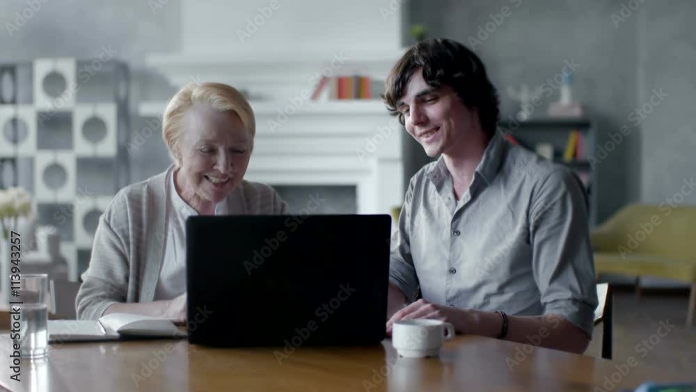 Grandson Teaching Grandmother How to Use a laptop PC. they smile and ...