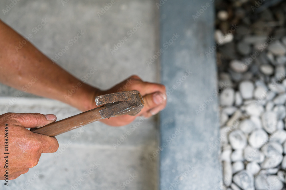 Closeup image of dirty worker hands doing hammer work on construction ...
