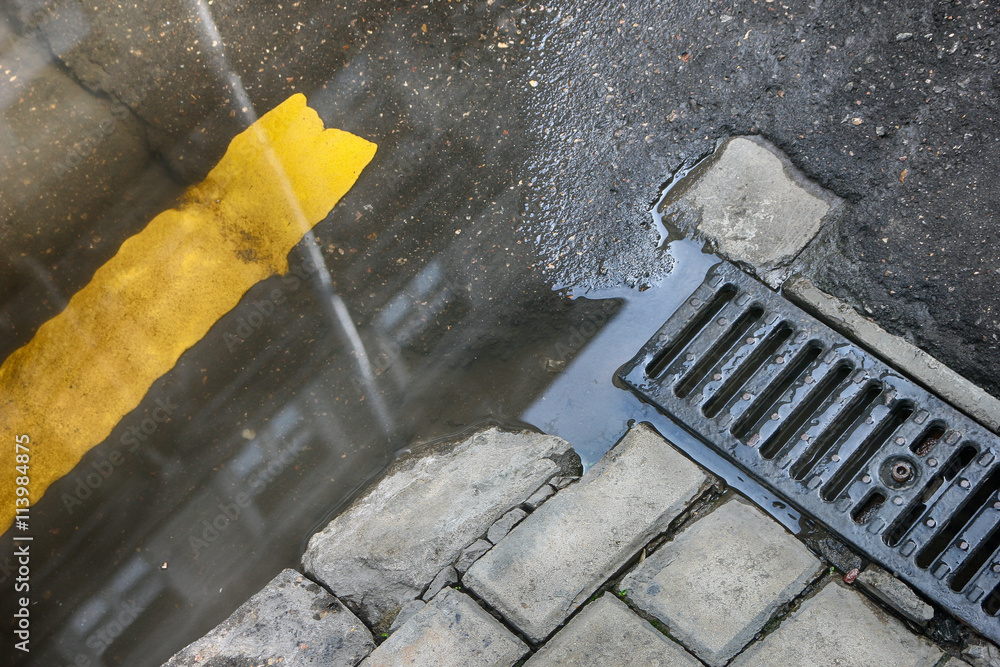 puddle on road at drainage metal grill of drainage tray on sidew Stock ...